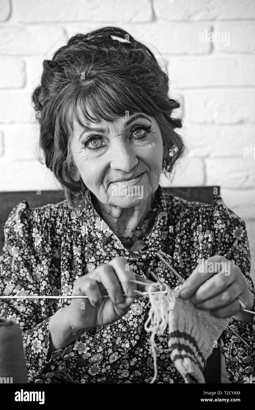 Granny character at Christmas eve. Old woman knitting socks from ...