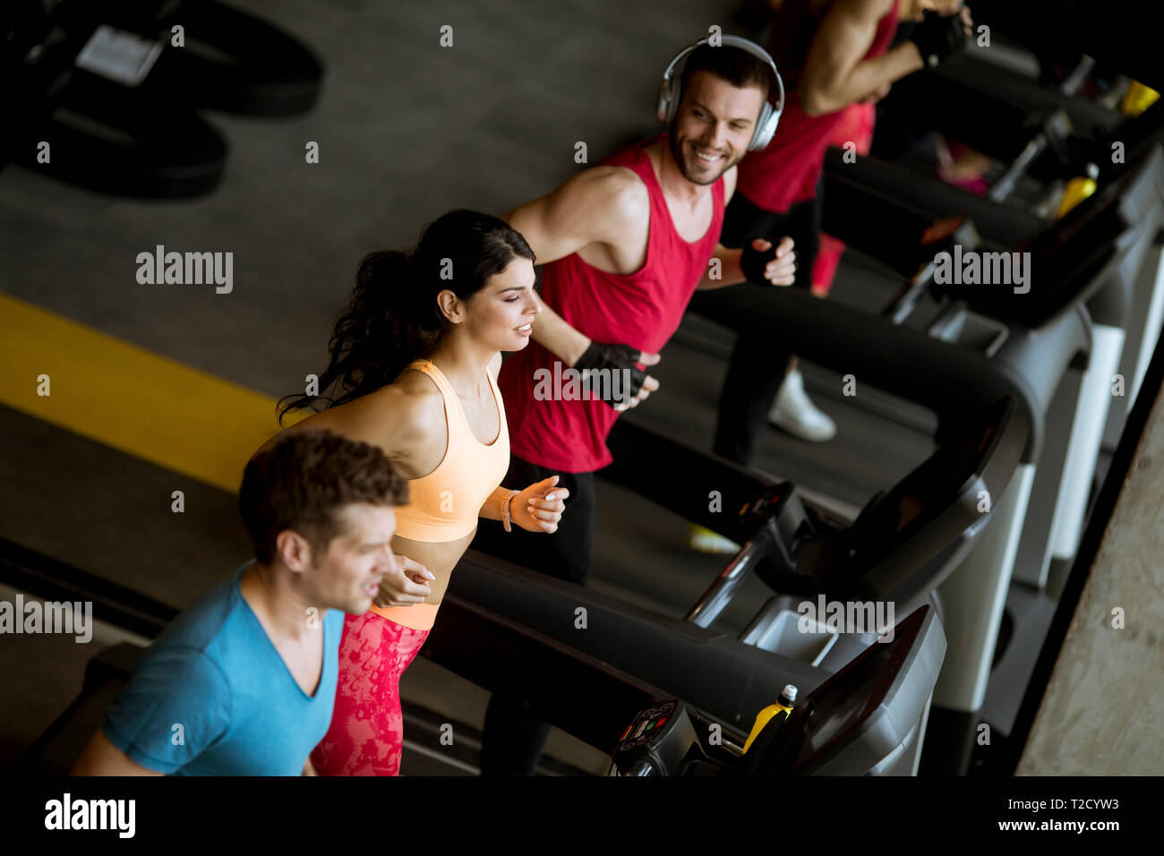 Group of young people running on treadmills in modern gym Stock Photo ...