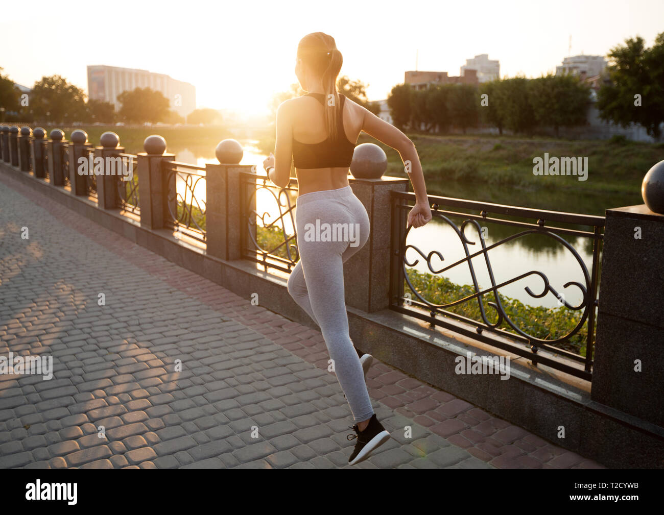 Running to sun. Active sporty woman training on quay, everyday jogging ...