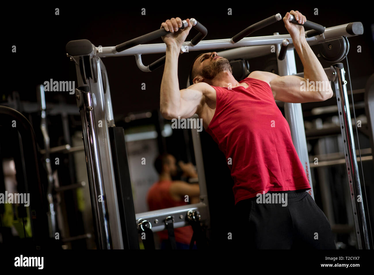 Athletic man doing workouts for a back with power exercise machine in a ...