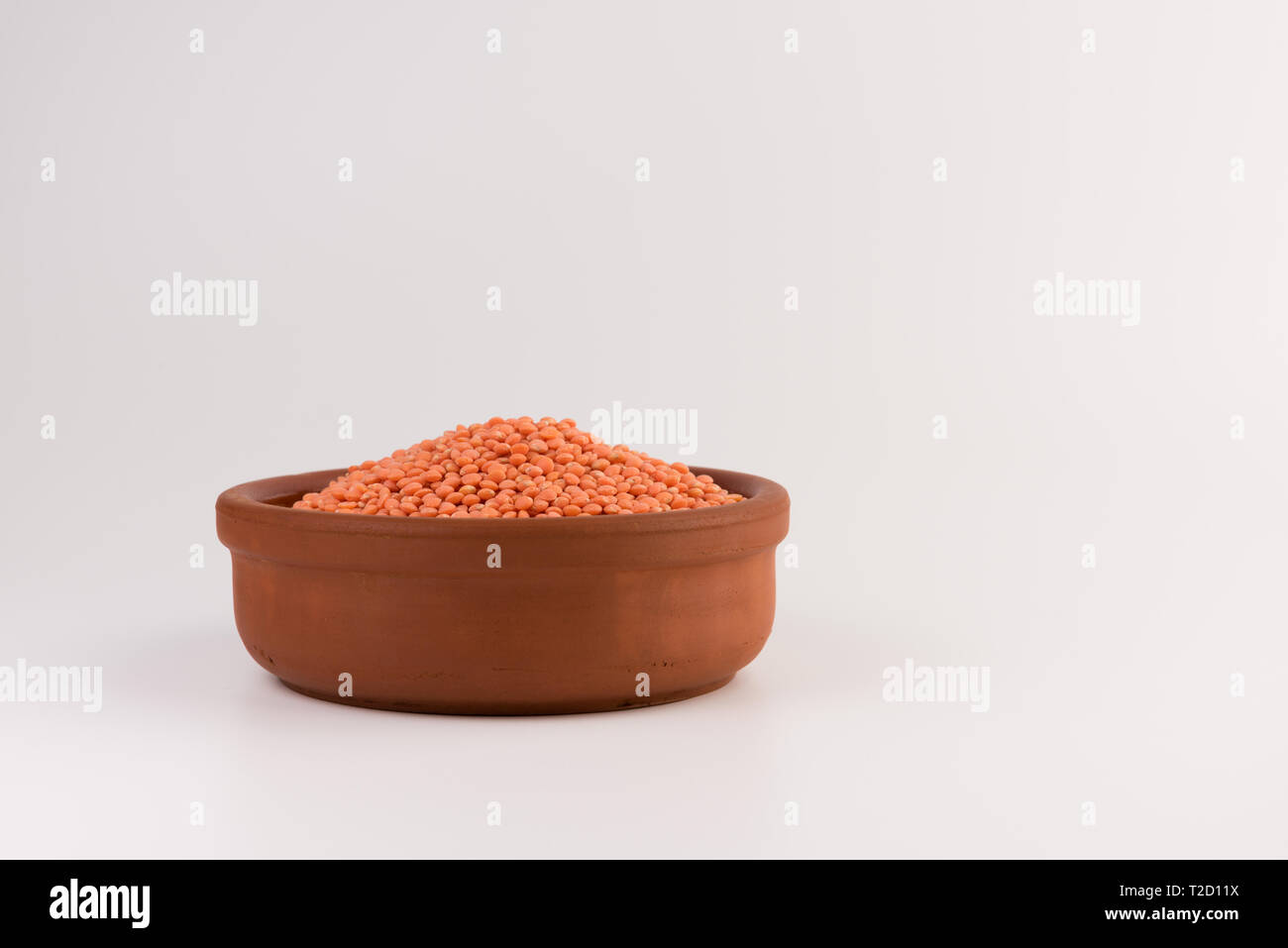 Red lentils in clay plate isolated on white background Stock Photo - Alamy