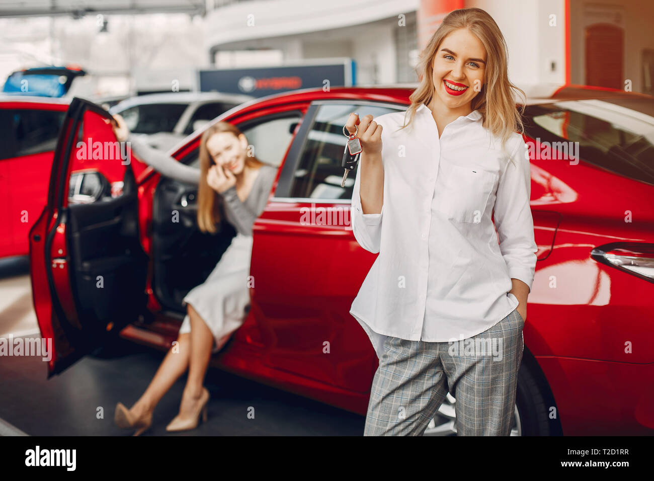 Women buying the car. Ladies in a car salon Stock Photo - Alamy