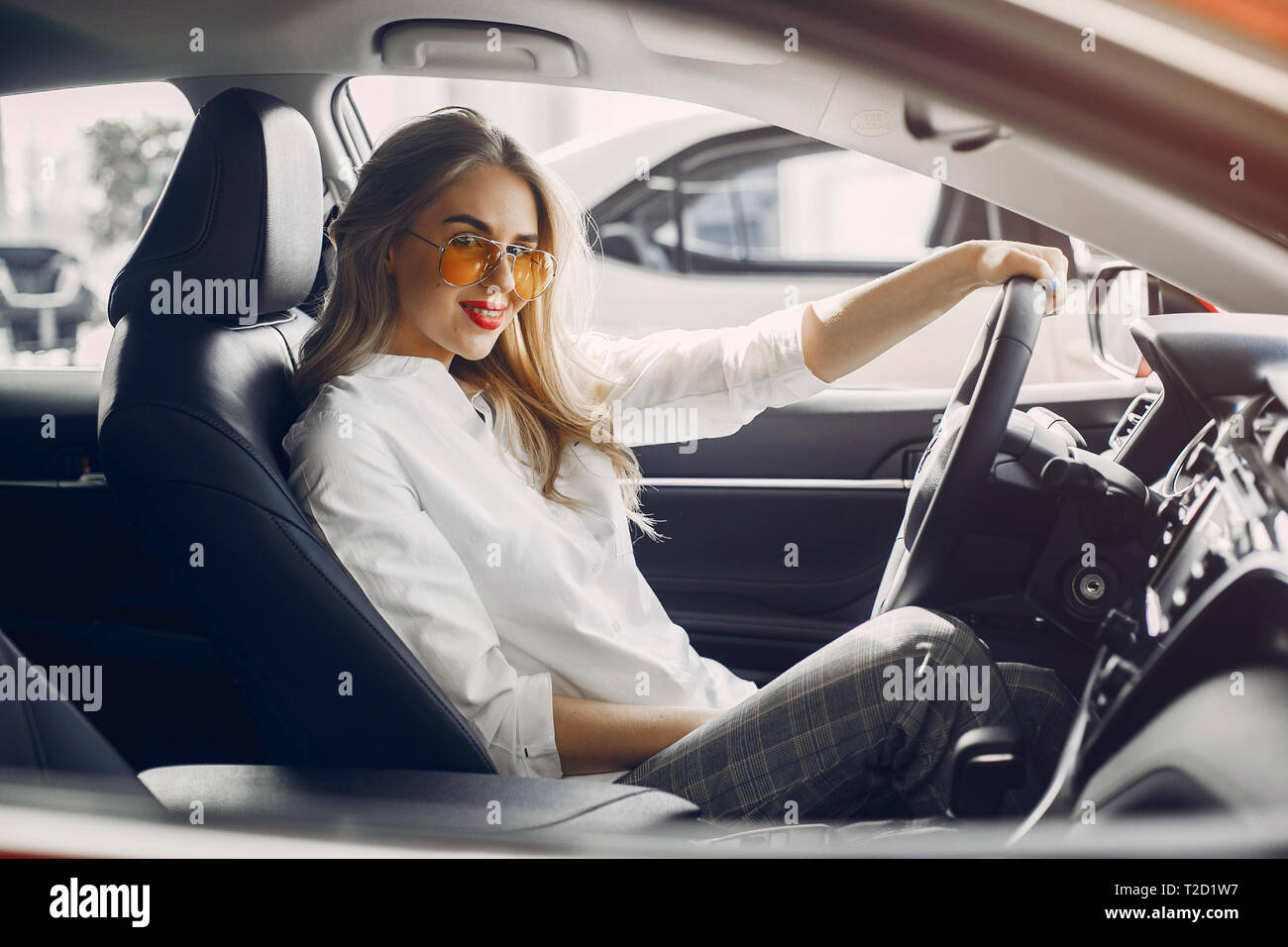 Woman buying the car. Lady in a car salon Stock Photo - Alamy