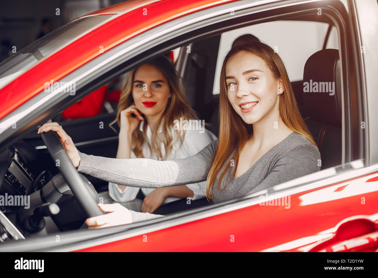 Women buying the car. Ladies in a car salon Stock Photo - Alamy