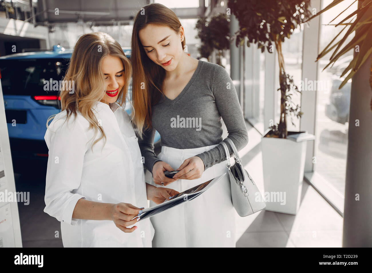 Women buying the car. Ladies in a car salon Stock Photo - Alamy
