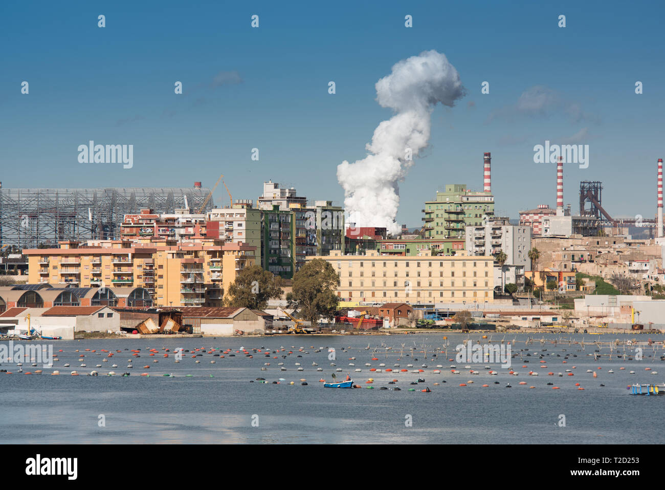 Wite smoke going up from the chimney. Taranto steel industry crossing ...