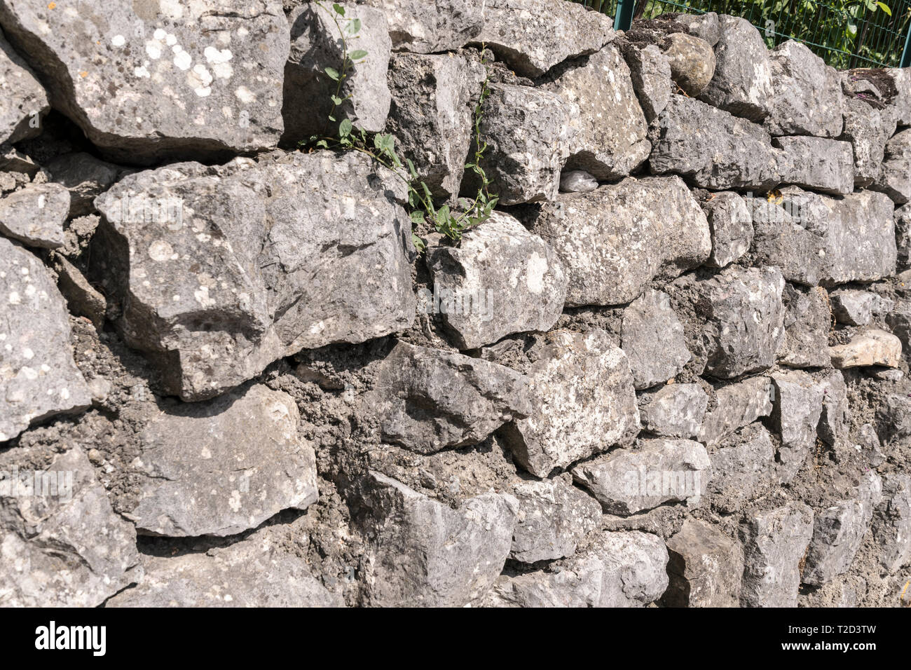 coarse stones as a wall a grey background Stock Photo - Alamy