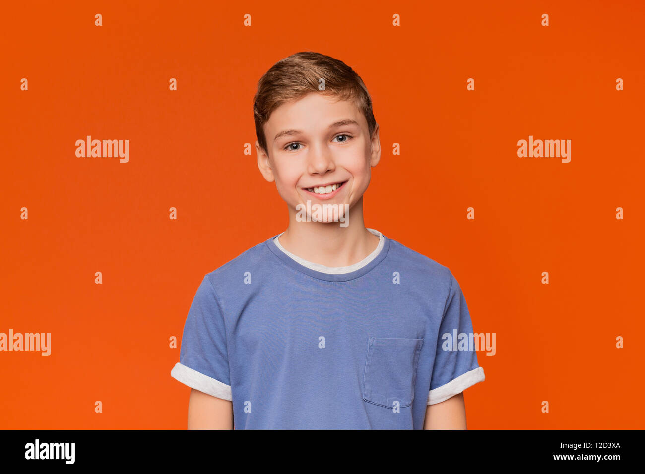 Portrait of young friendly boy on orange studio background Stock Photo ...