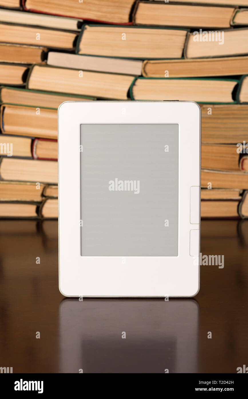 Electronic book on background of regular old books Stock Photo - Alamy