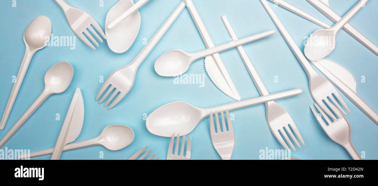 Single-use plastic products: plastic cutlery on bright blue background ...