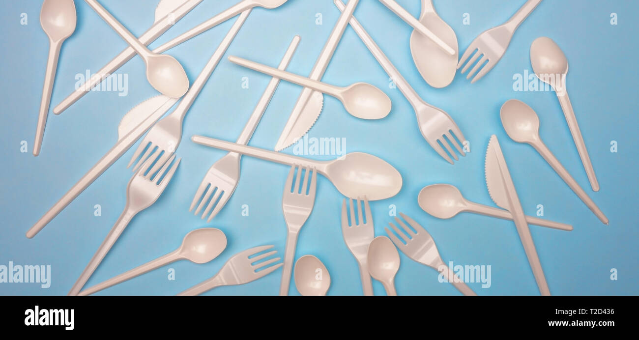 Single-use plastic products: plastic cutlery on bright blue background ...