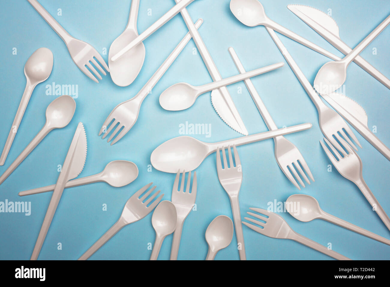 Single-use plastic products: plastic cutlery on bright blue background ...