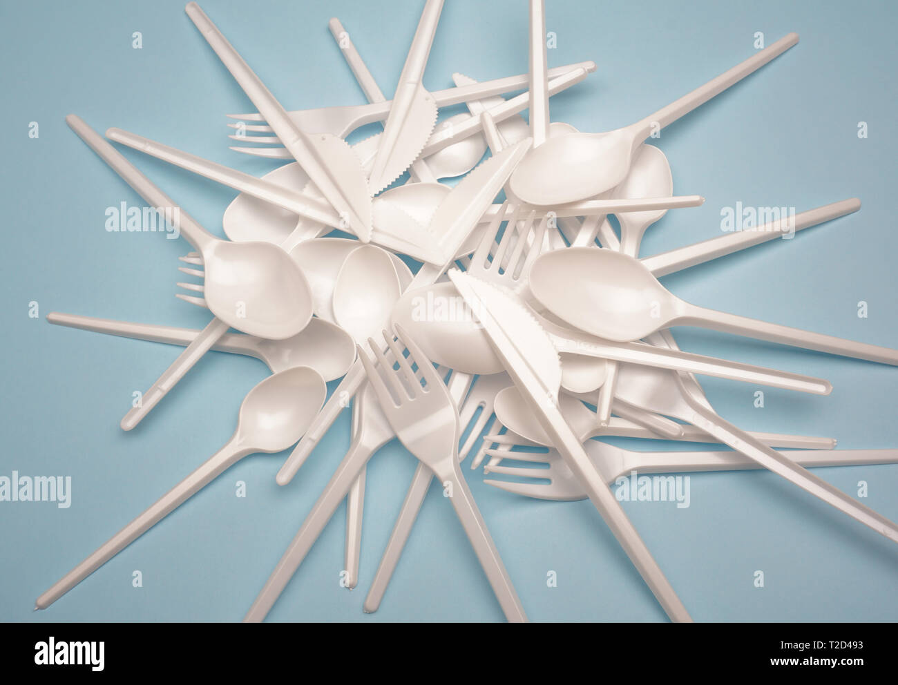 Single-use plastic products: plastic cutlery on bright blue background ...