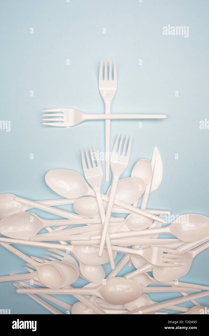 Single-use plastic products: plastic cutlery on bright blue background ...