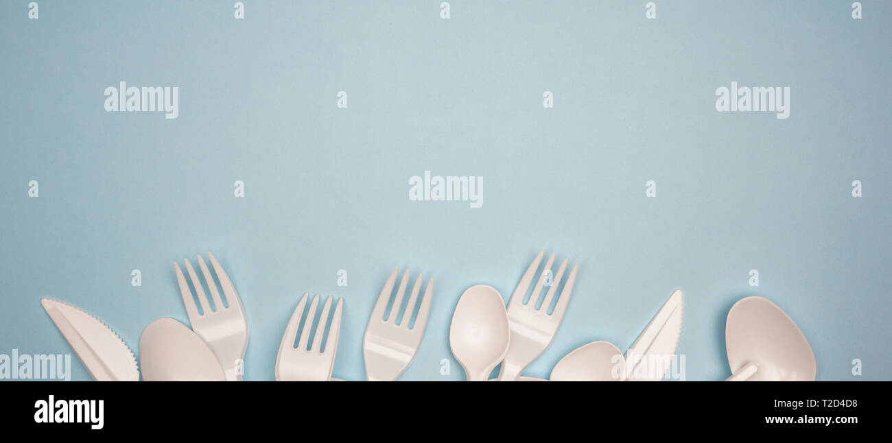 Single-use plastic products: plastic cutlery on bright blue background ...