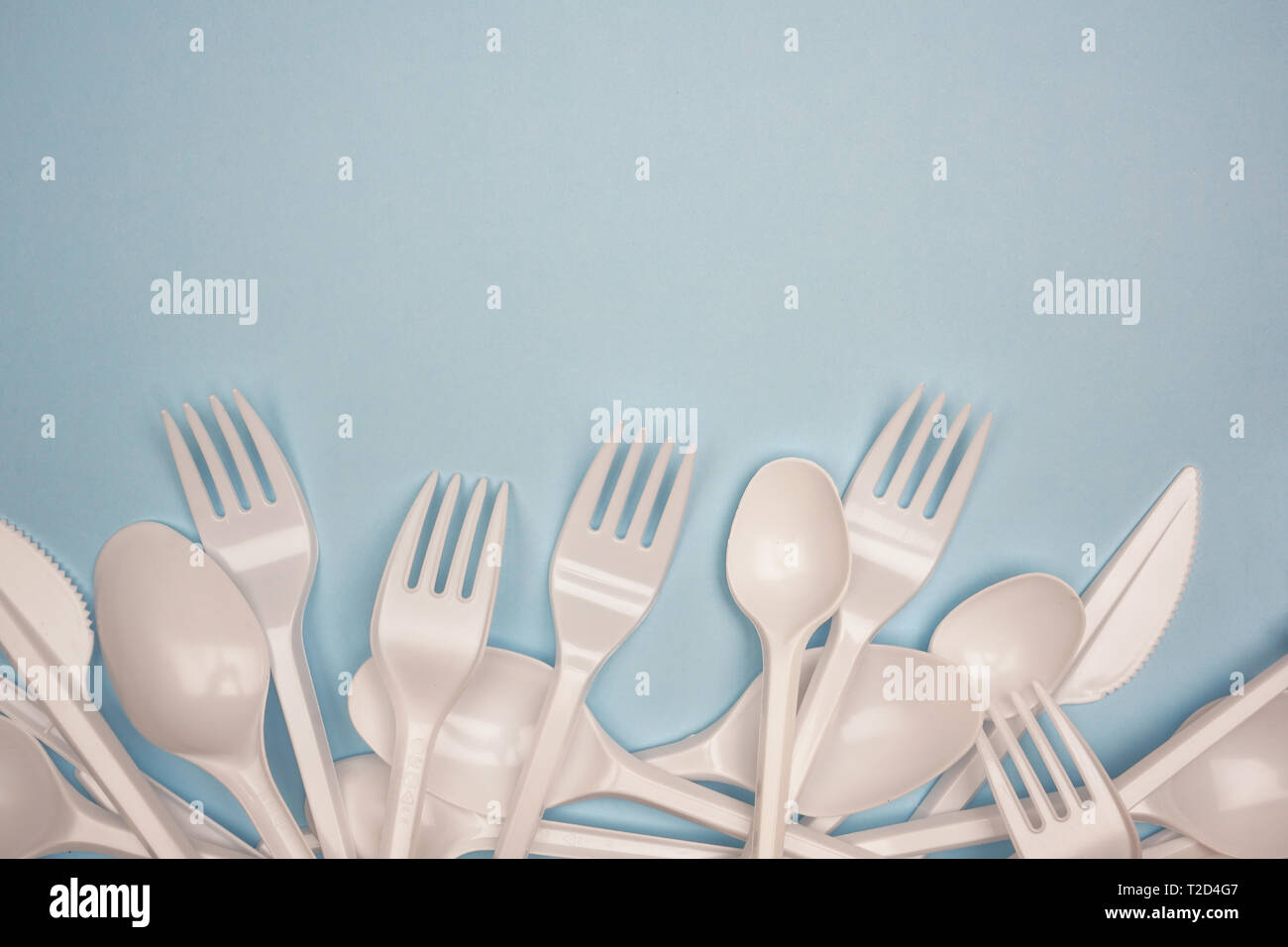 Single-use plastic products: plastic cutlery on bright blue background ...