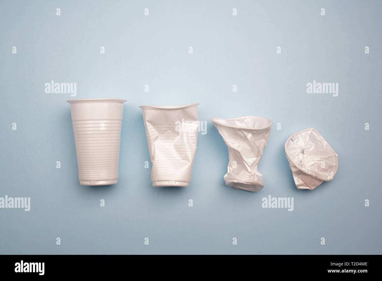 Crumpled plastic cups on bright blue background. Creative minimal ...