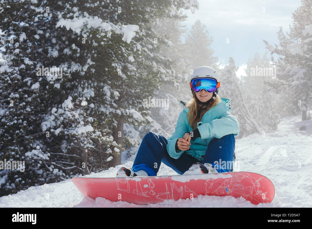 Snowboarder in the mountains. Girl on a snowboard comes down from the ...