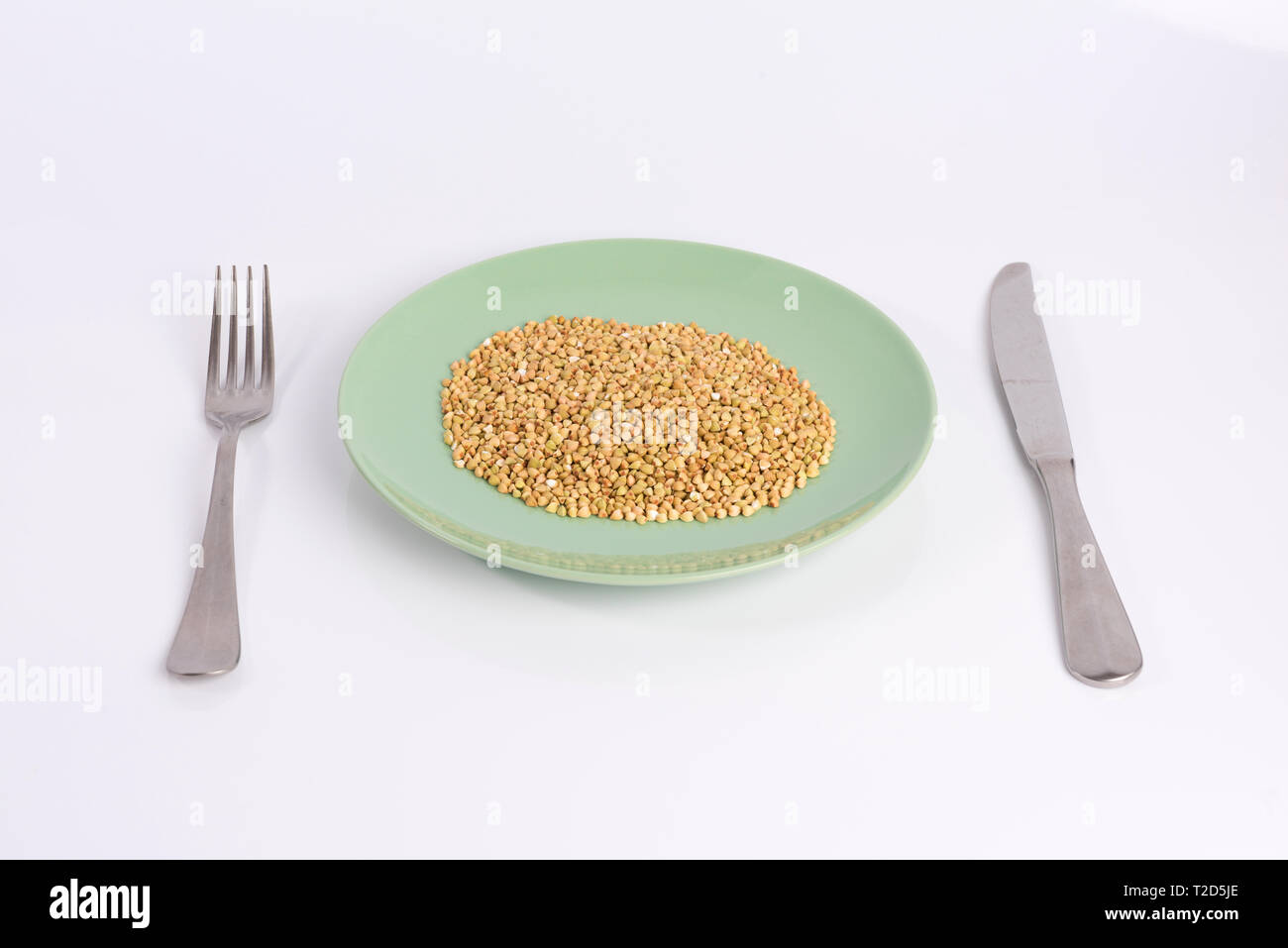 green buckwheat on a plate isolated on white background Stock Photo - Alamy