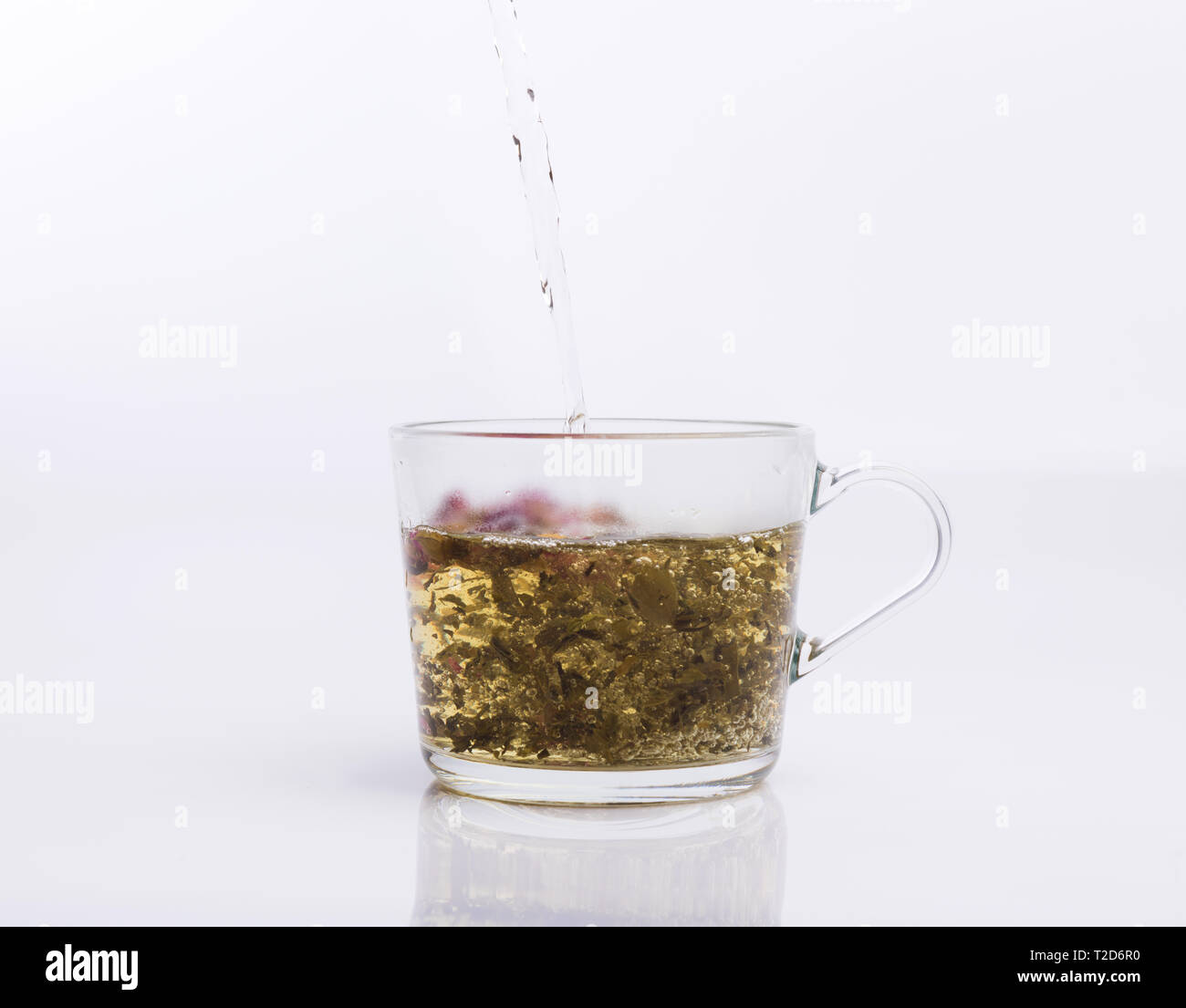Tea pouring into glass cup isolated on white background Stock Photo - Alamy