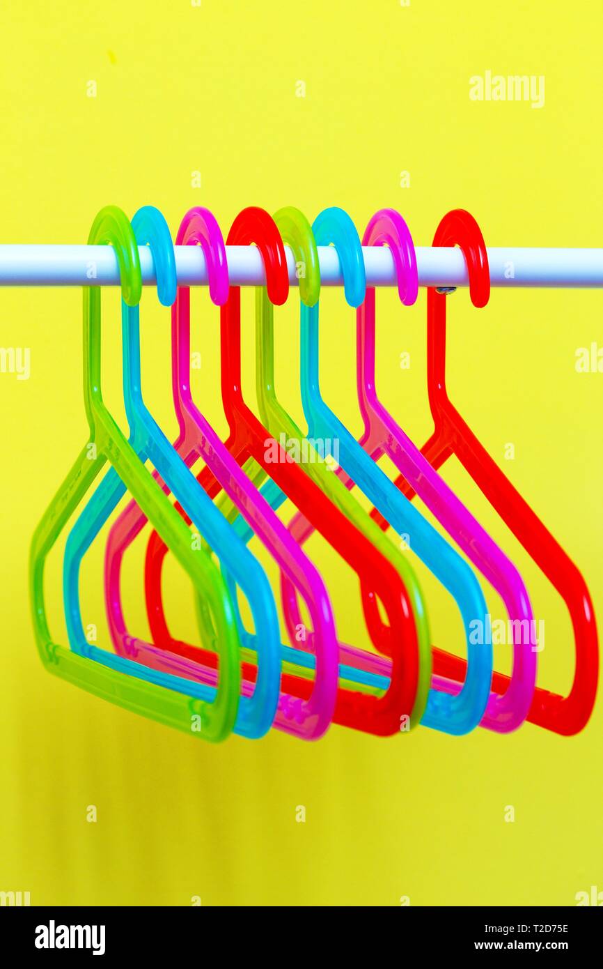 multicolored hangers on yellow background with small depth of field ...