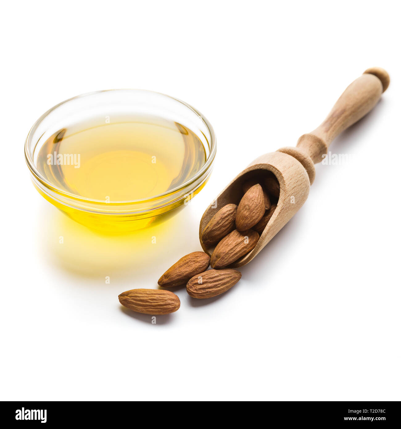 Almond oil in glass bowl and scoop with almonds isolated on white ...