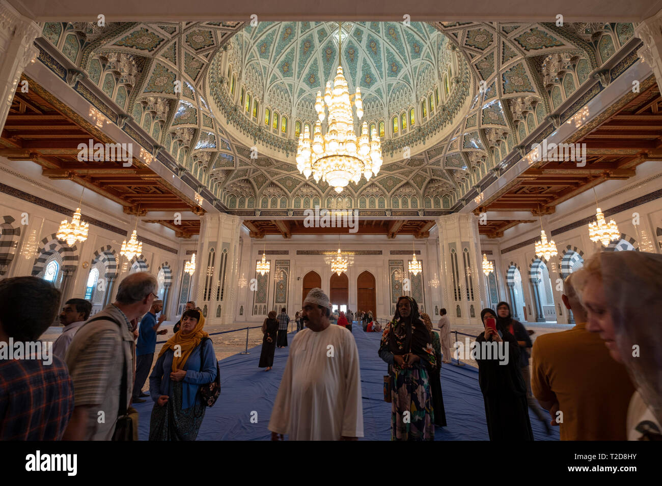 Tourists inside the prayer hall at Sultan Qaboos Grand Mosque in Muscat ...