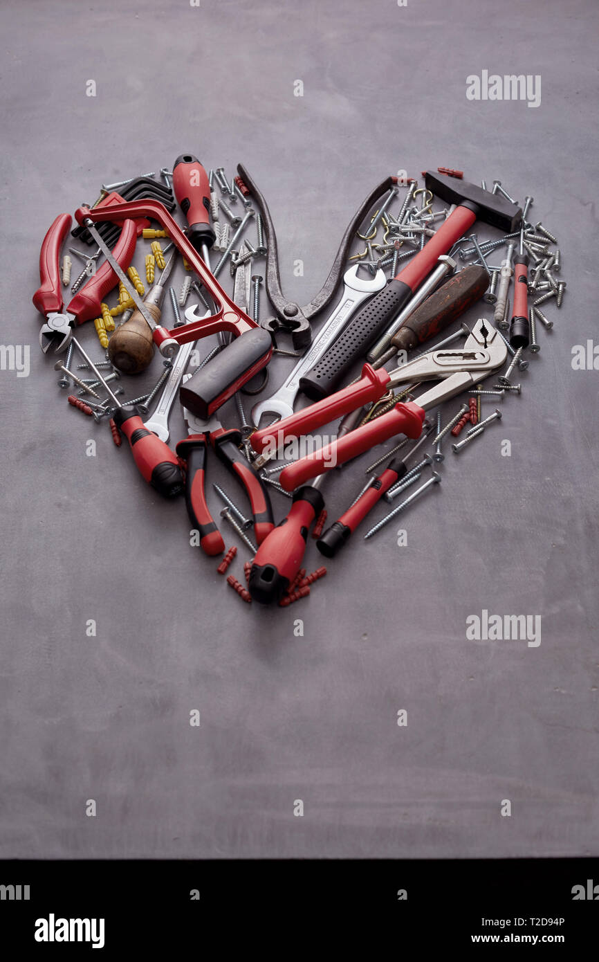 Heart-shaped still life of colorful red hand tools for woodworking and ...