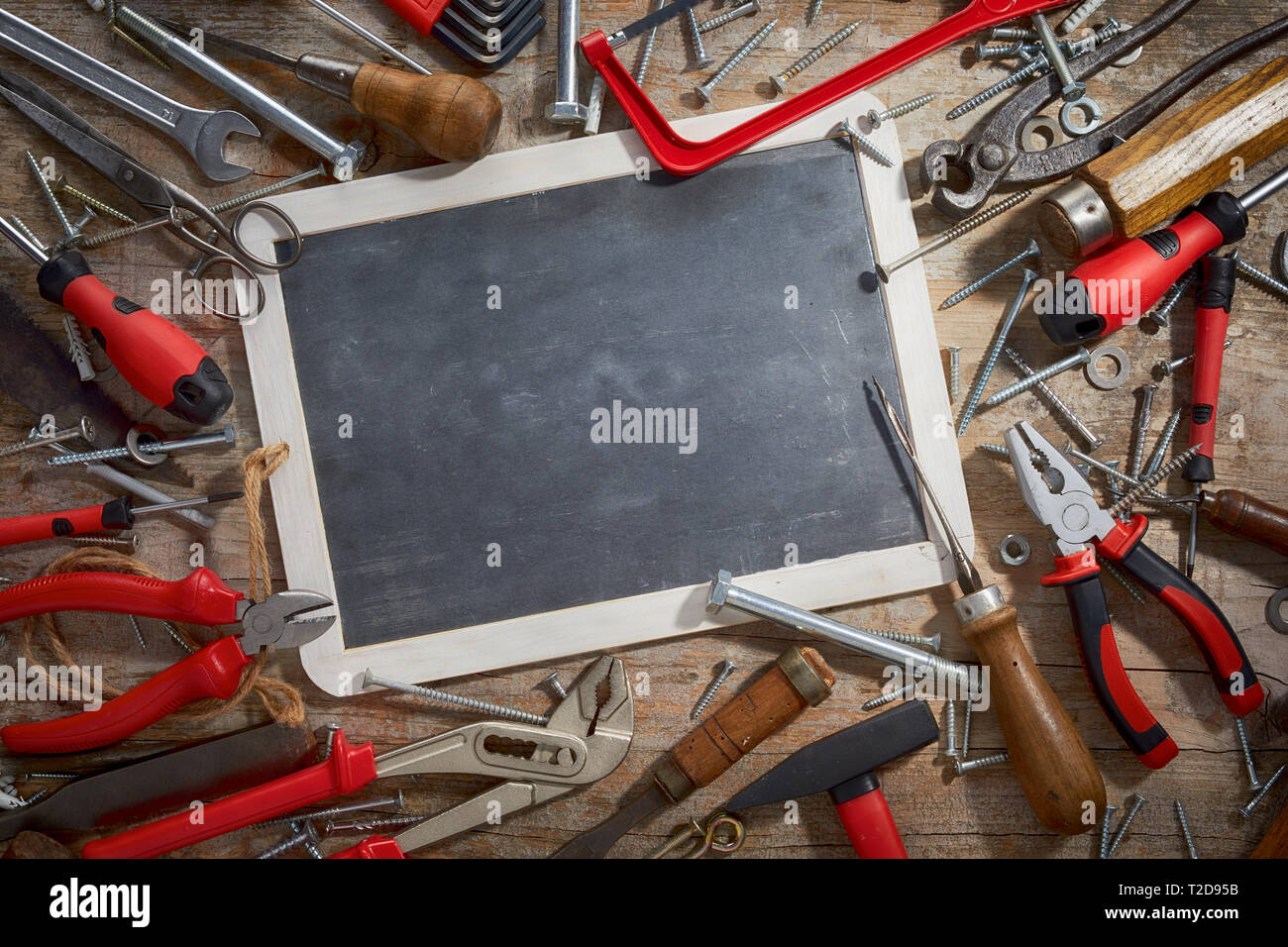Assorted vintage and new tools in a frame surrounding on old chalkboard ...
