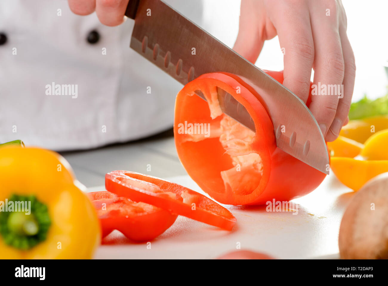 Cutting a red bell pepper into ring slices. Preparing vegetables for a ...