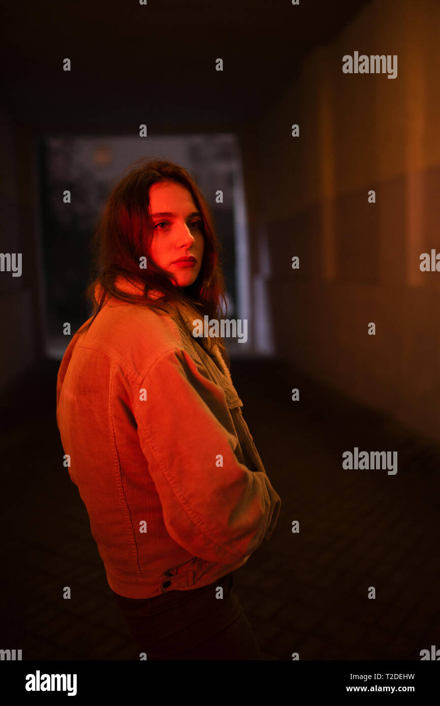 young woman lit in red light in a winter jacket Stock Photo - Alamy