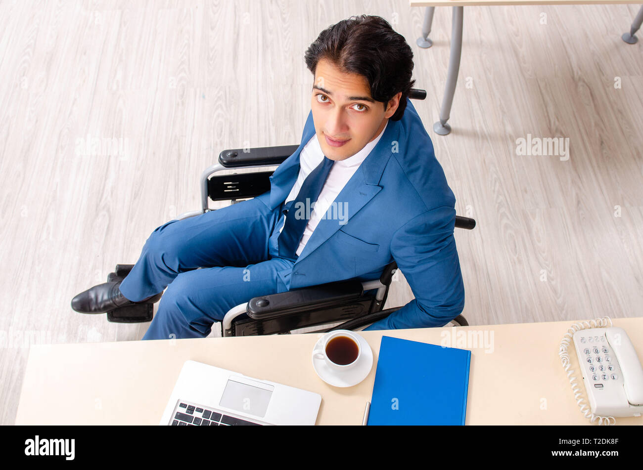 Male employee in wheelchair working at the office Stock Photo - Alamy