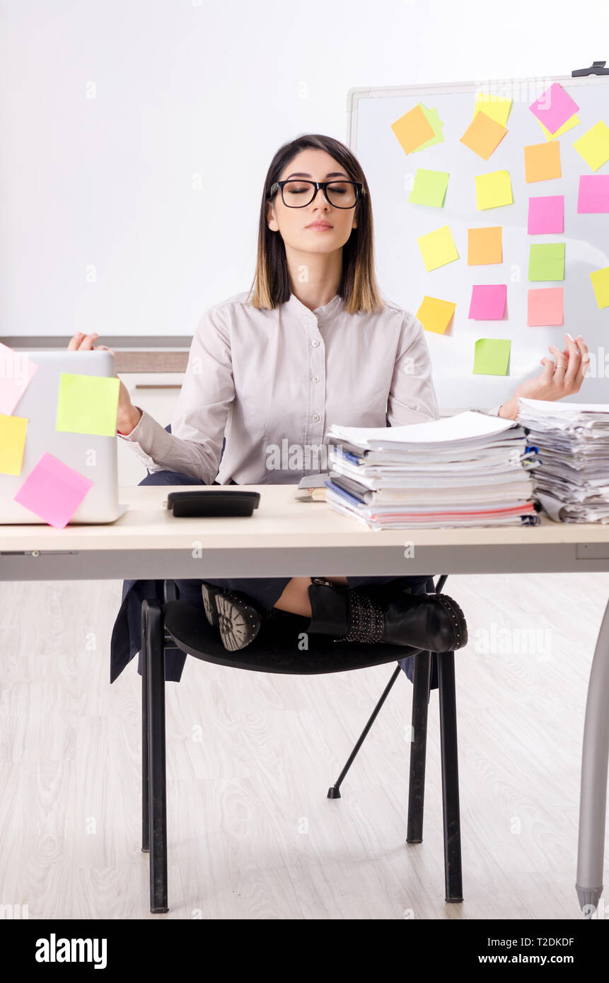 Young female employee doing exercises at workplace Stock Photo - Alamy