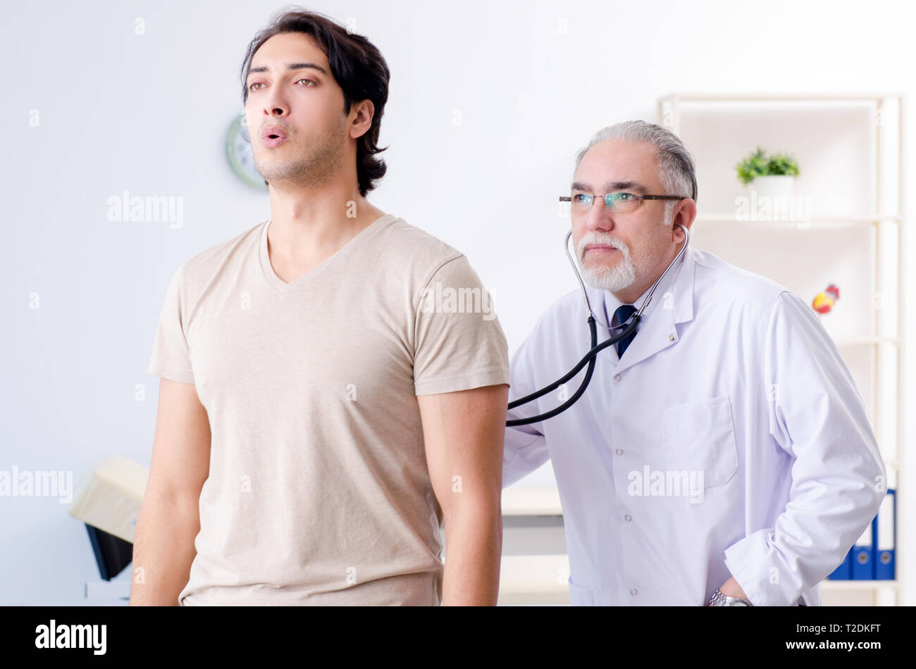 Young male patient visiting old doctor Stock Photo - Alamy