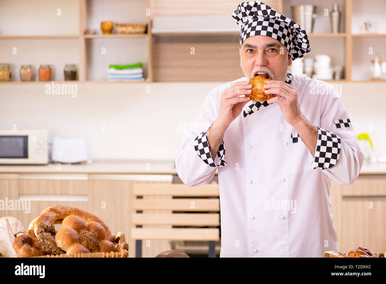 Old male baker working in the kitchen Stock Photo - Alamy