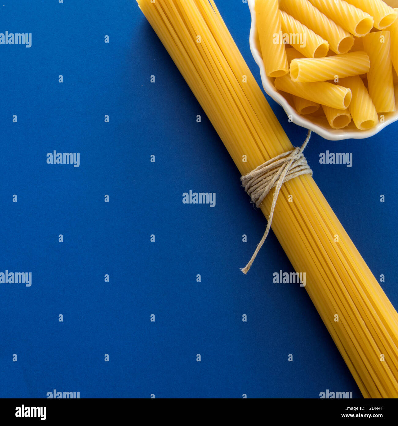 Different Italian pasta products on blue background, space for menu or ...