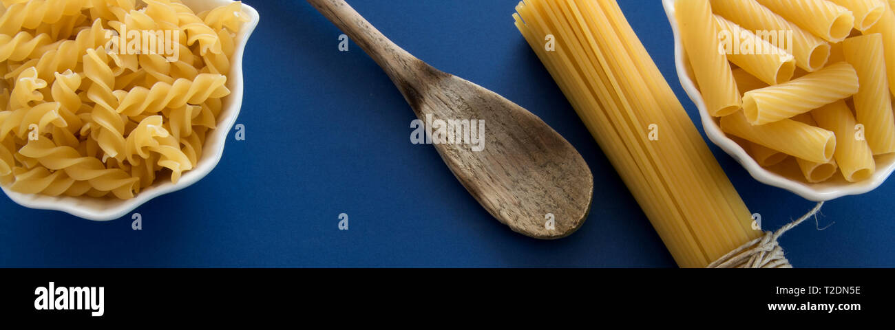Different Italian pasta products on blue background Stock Photo - Alamy