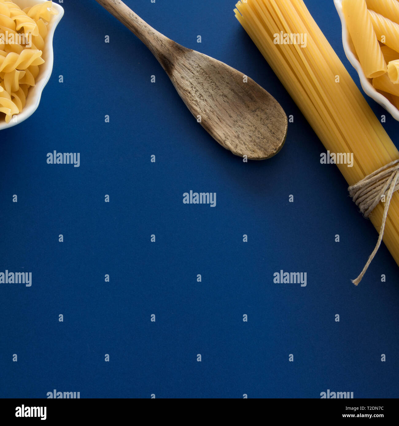 Different Italian pasta products on blue background, space for menu or ...