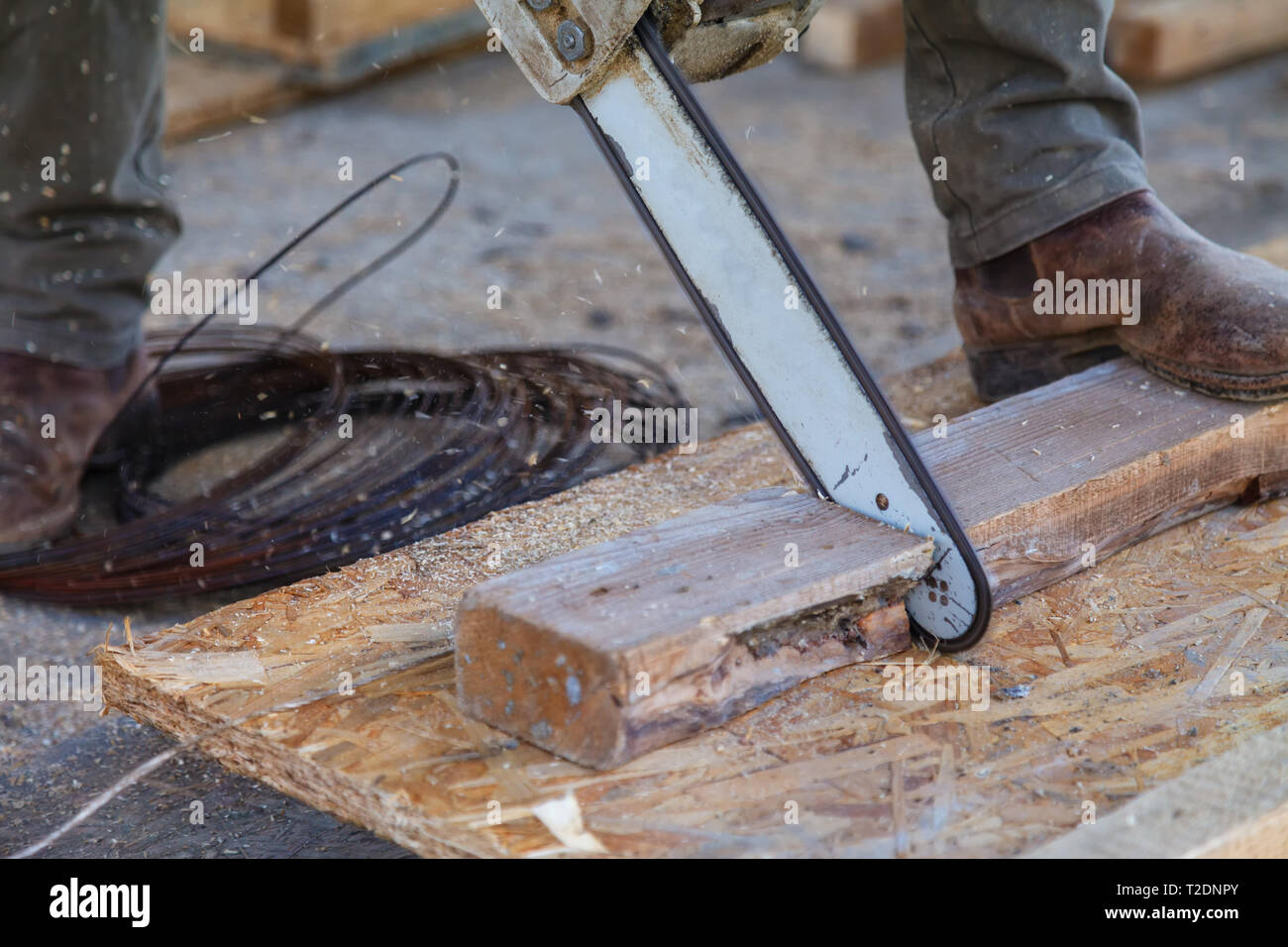 A man using a chainsaw saws a wooden beam Stock Photo - Alamy