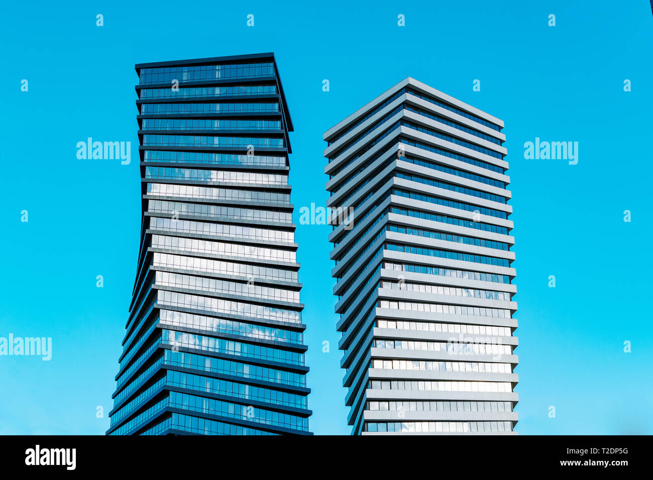 Two modern tall business skyscrapers with lot of glass windows against ...