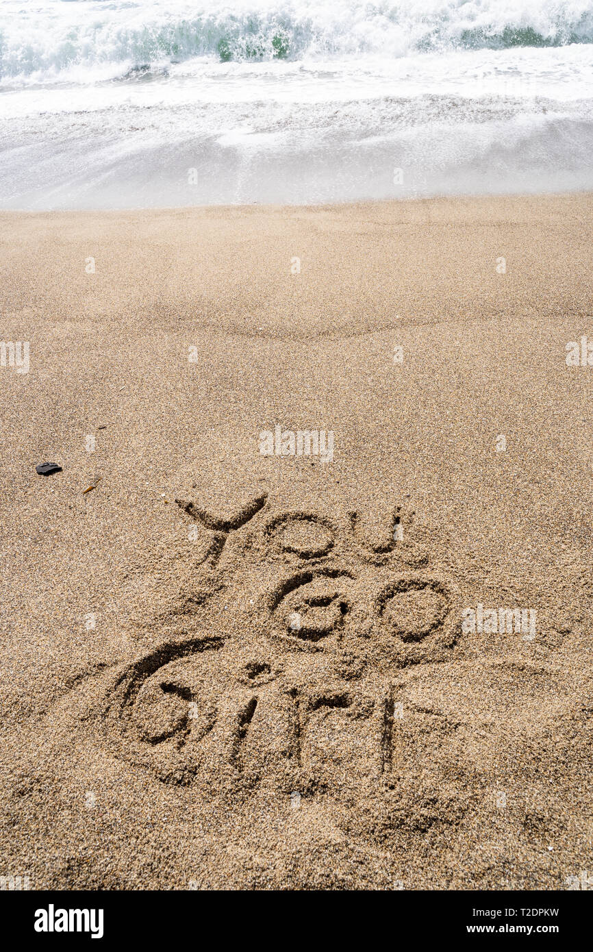 popular-90s-slang-phrase-you-go-girl-written-in-sand-on-the-beach
