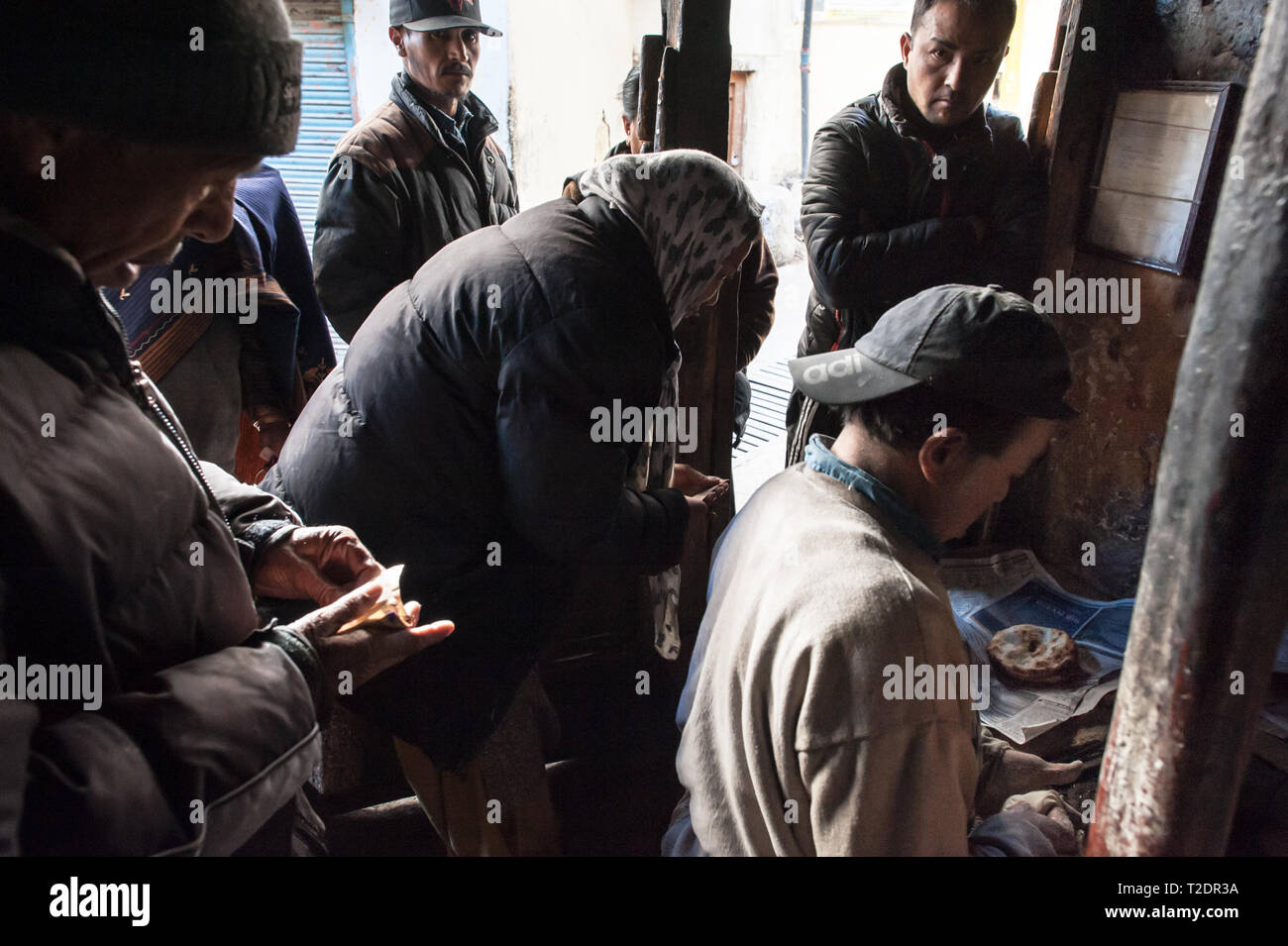 Locals queue in the cold, early morning light for freshly cooked bread ...