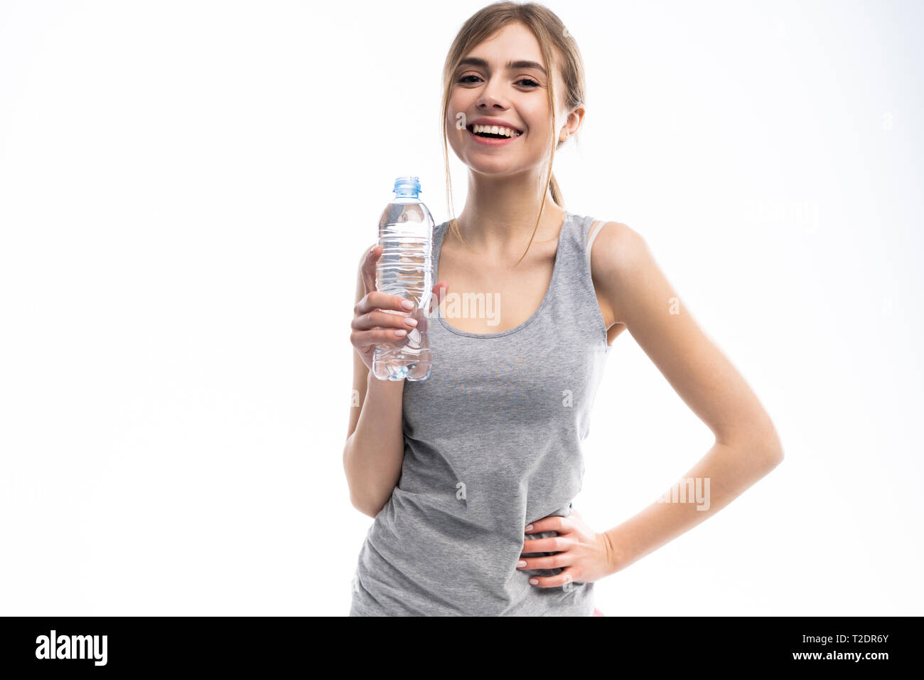 Female fitness model holding a water bottle in a white studio ...