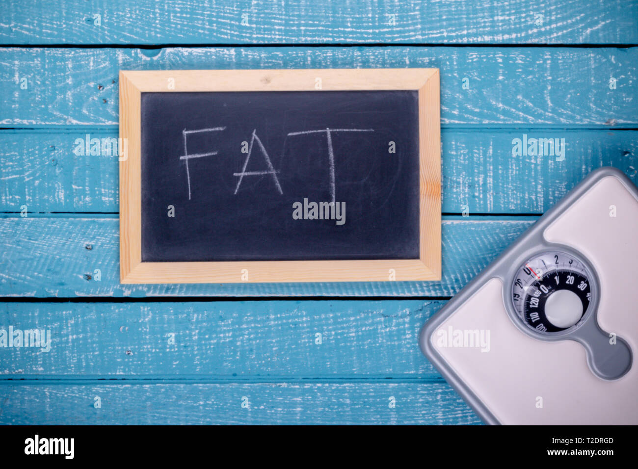 Weight loss concept showing a bathroom scales and a chalkboard reading ...