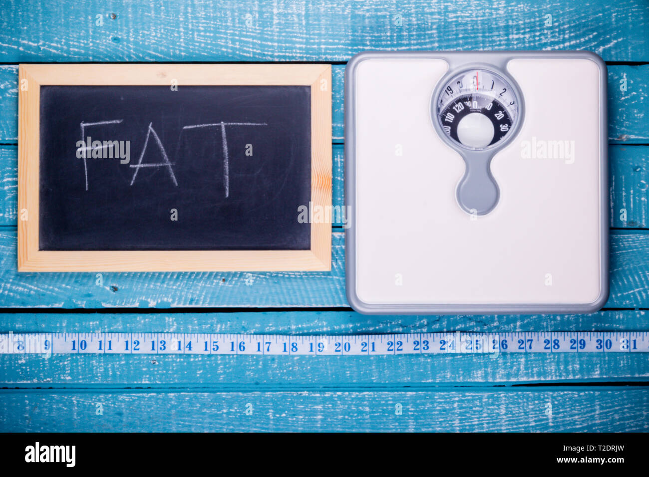 Weight loss concept showing a bathroom scales and a chalkboard reading ...