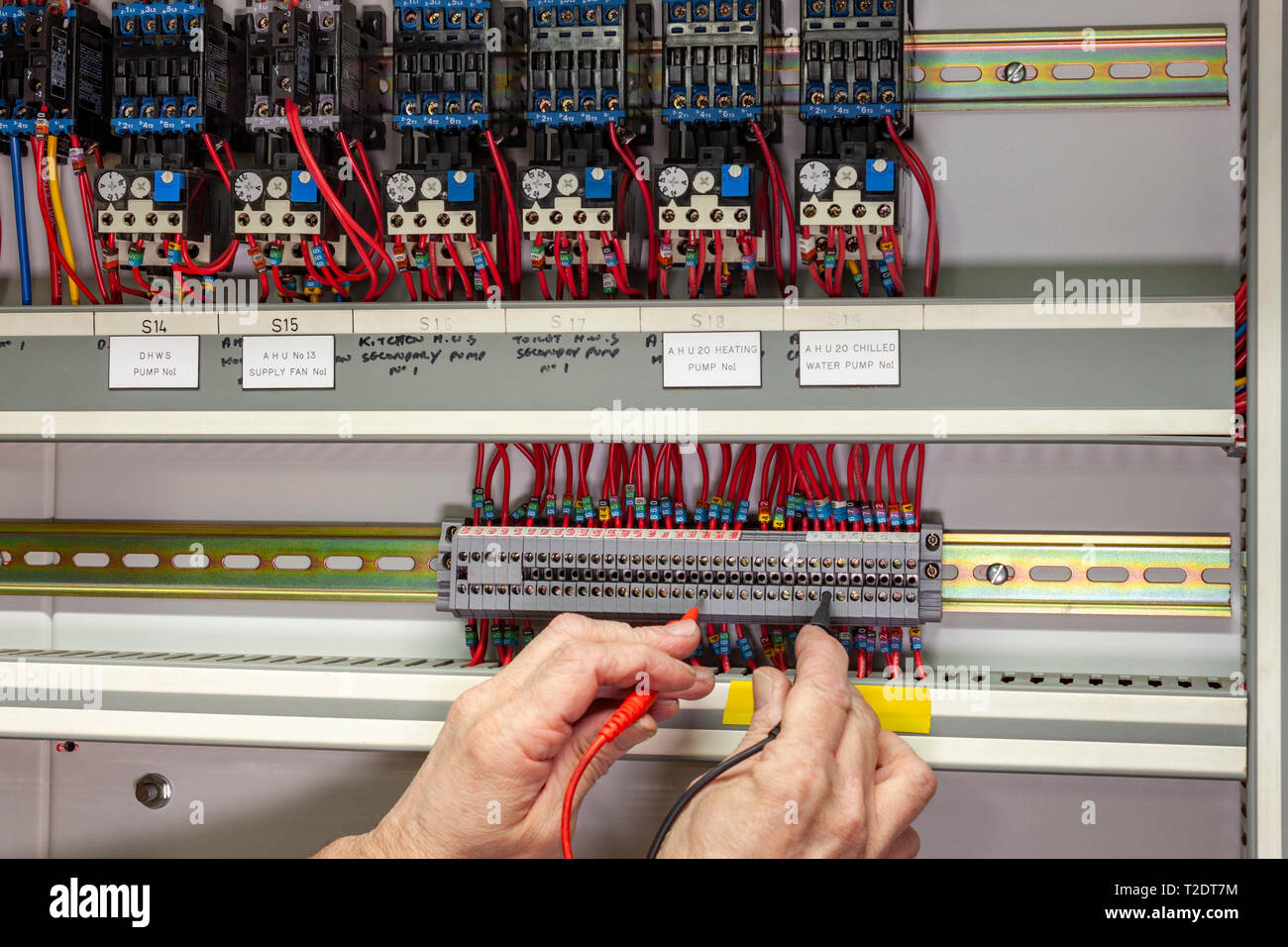 Electrical engineer testing some wiring in a control panel Stock Photo ...