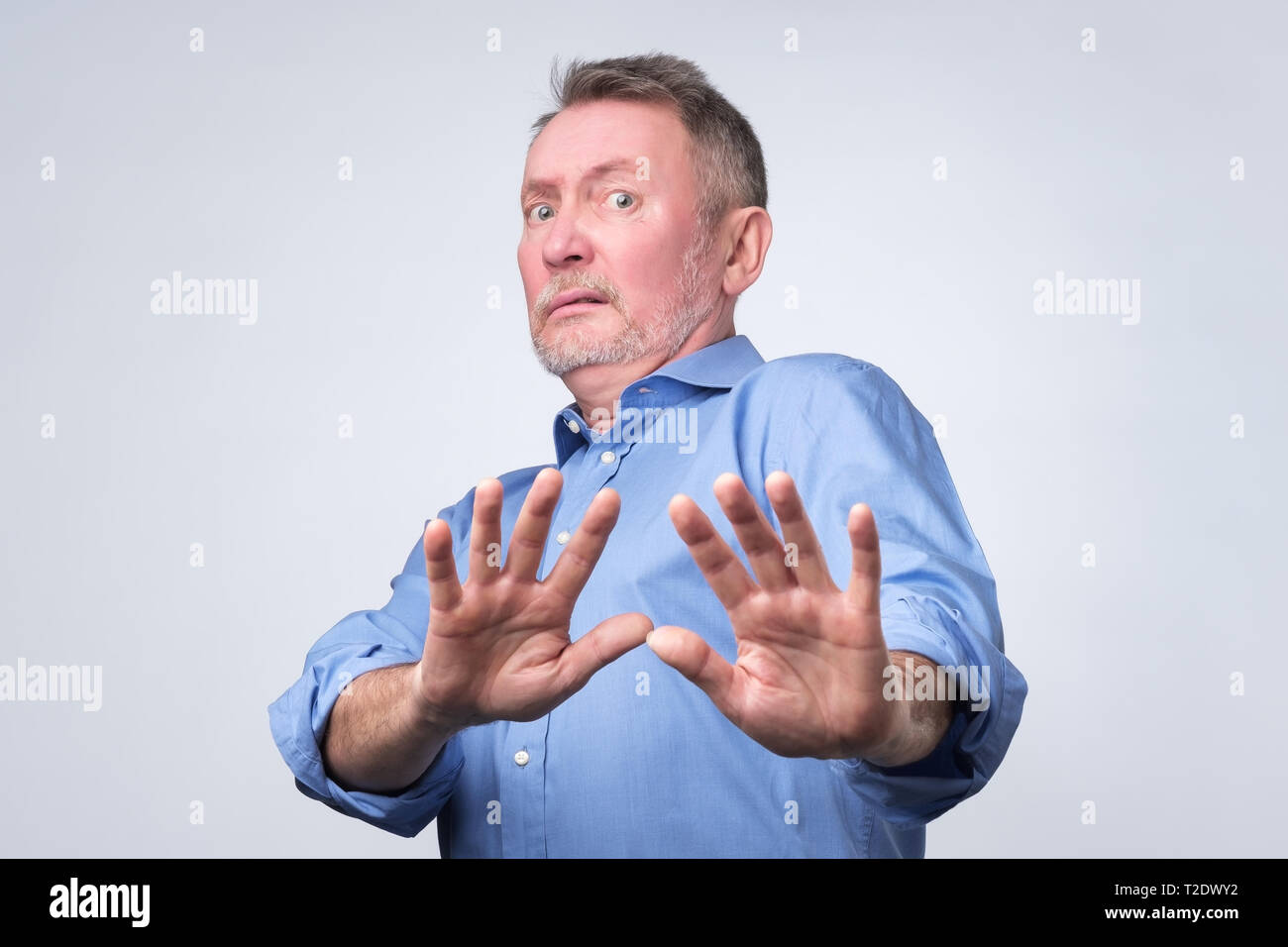 Handsome senior european man in blue shirt making stop sign. It's not ...