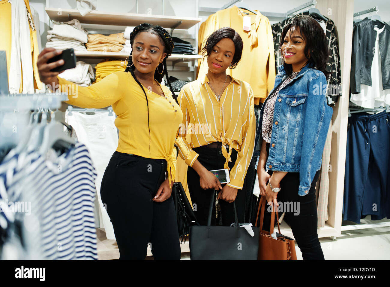 Three african woman at clothes store. Shopping day and time for selfie ...
