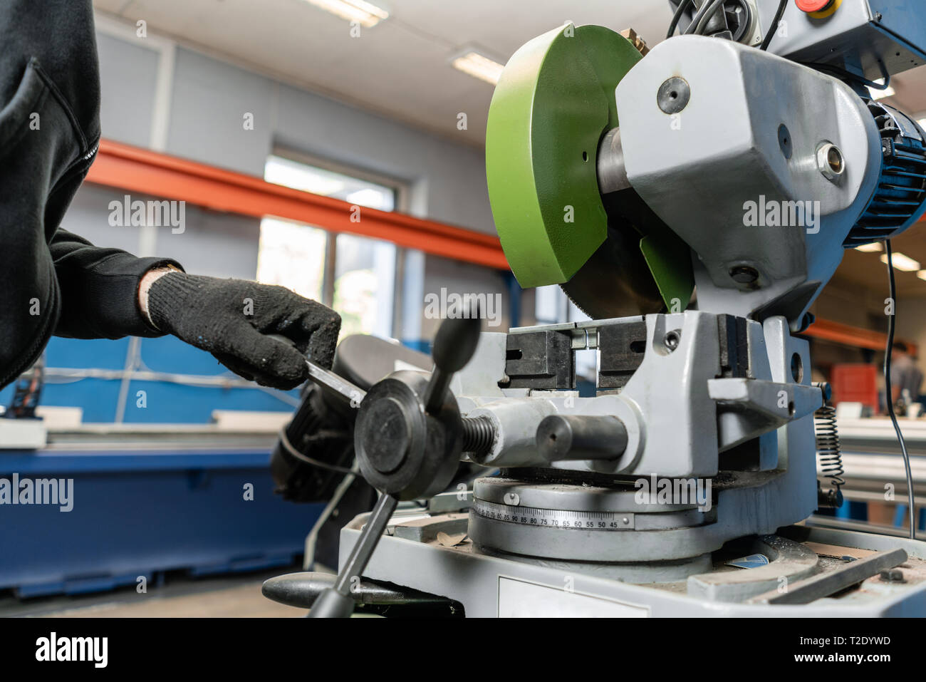 worker cuts a piece of material with a circular saw machine. Industrial ...