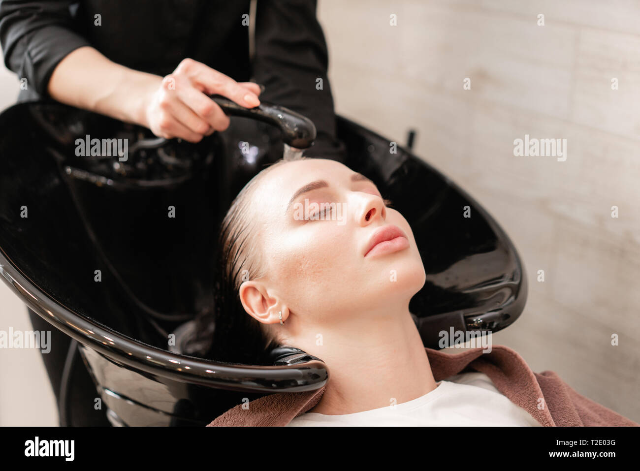 beautiful girl washes her hair before a haircut in a beauty salon. hair ...